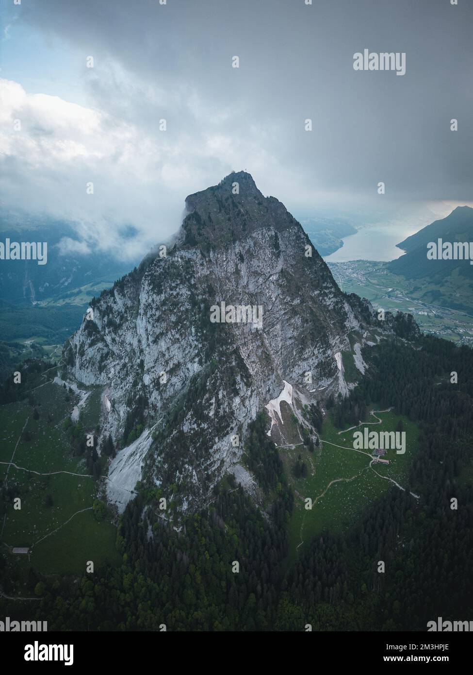 A drone vertical shot of a mountain with rocky peak and greenery under ...