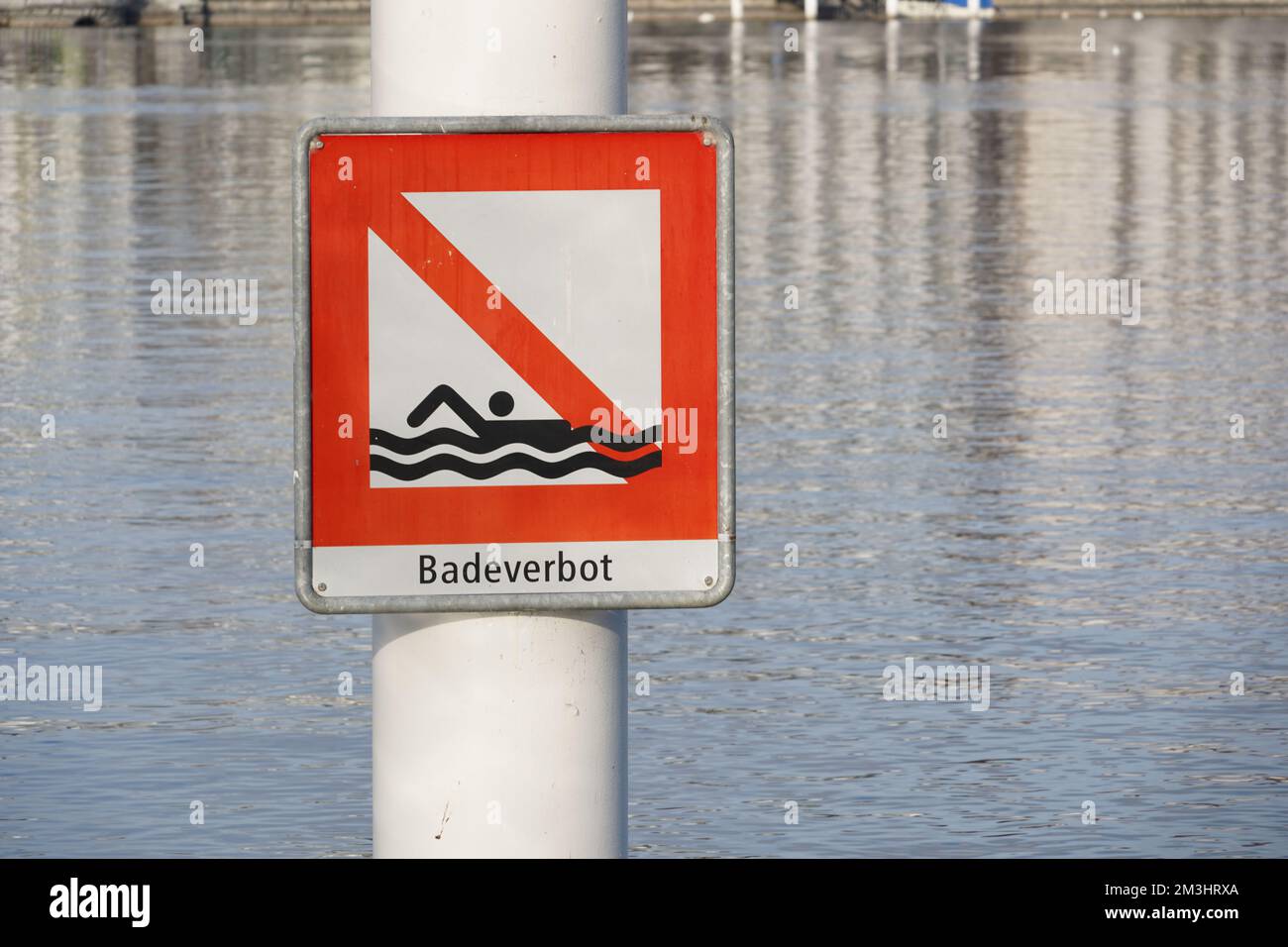 Red square signpost saying in German bathing prohibited attached on a ...
