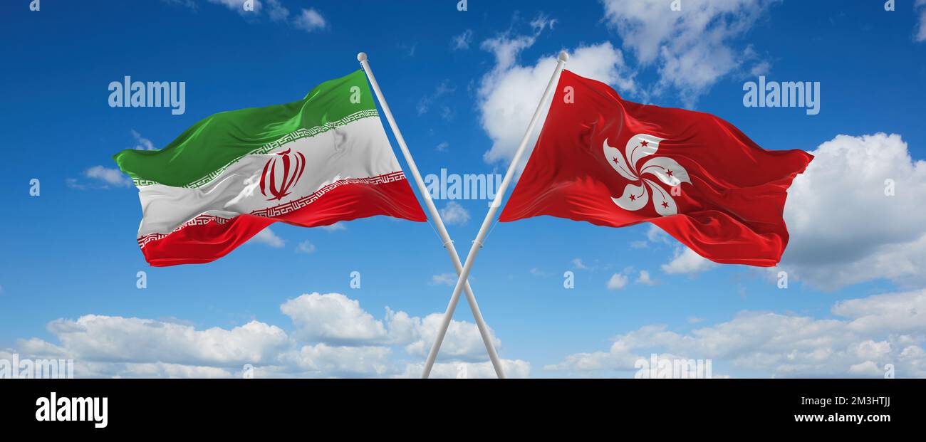 two crossed flags Hong Kong and Iran waving in wind at cloudy sky ...