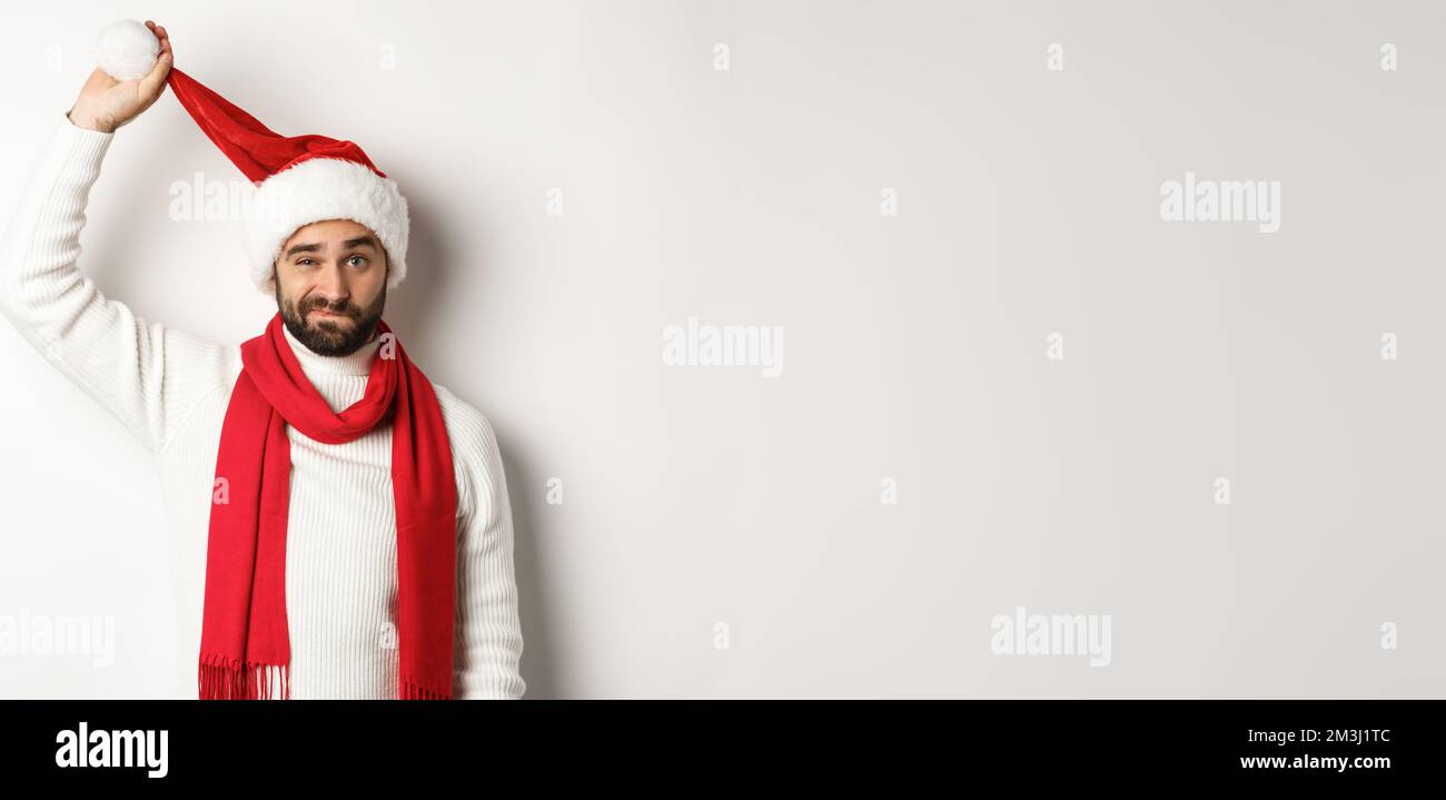 Christmas party and celebration concept. Sad guy taking-off Santa hat ...