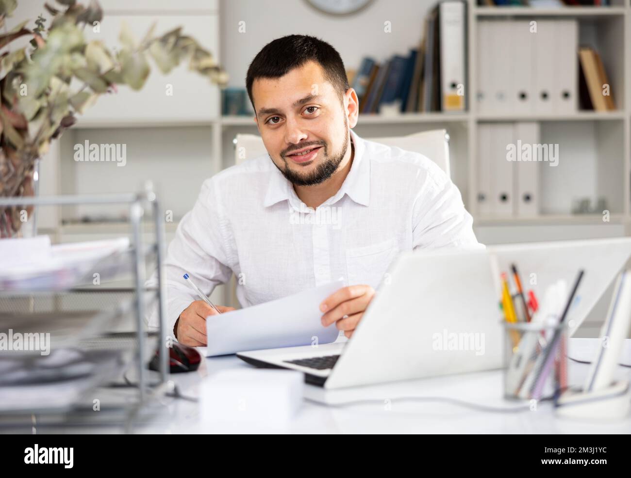 Smiling businessman doing his daily work in office Stock Photo - Alamy