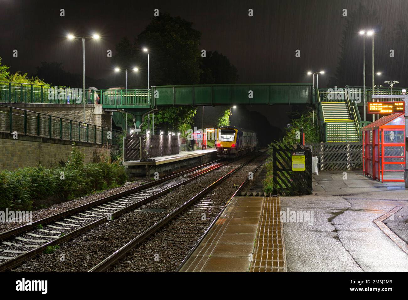Woodlesford Railway station, Yorkshire, UK. A Northern rail class 195 train calls on a wet night ...