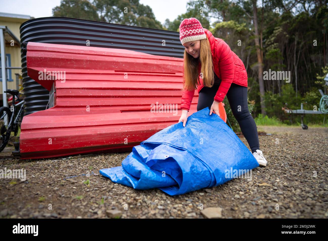 folding up a blue tarp after camping at a music festival in australia ...