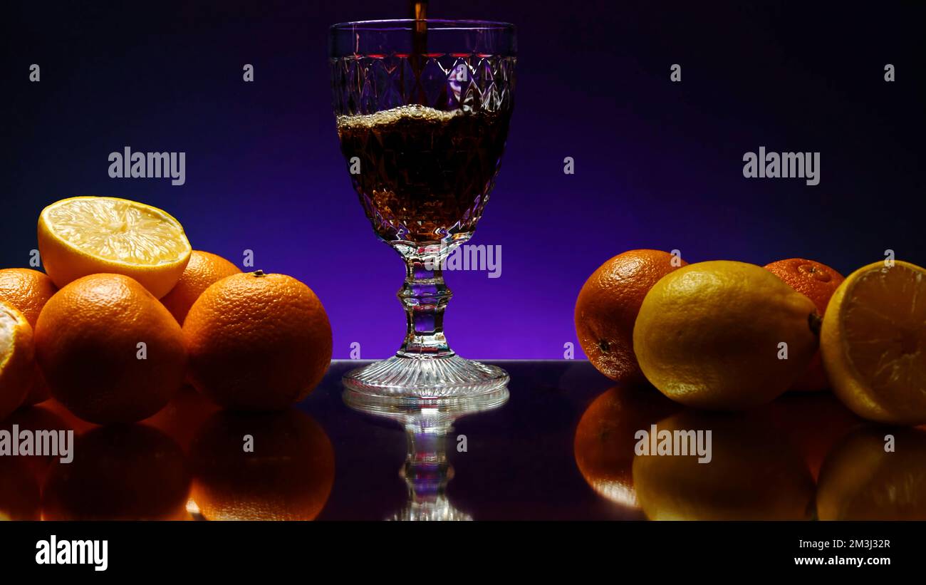 Rum drink being poured into long glass, isolated on colorful lighted ...