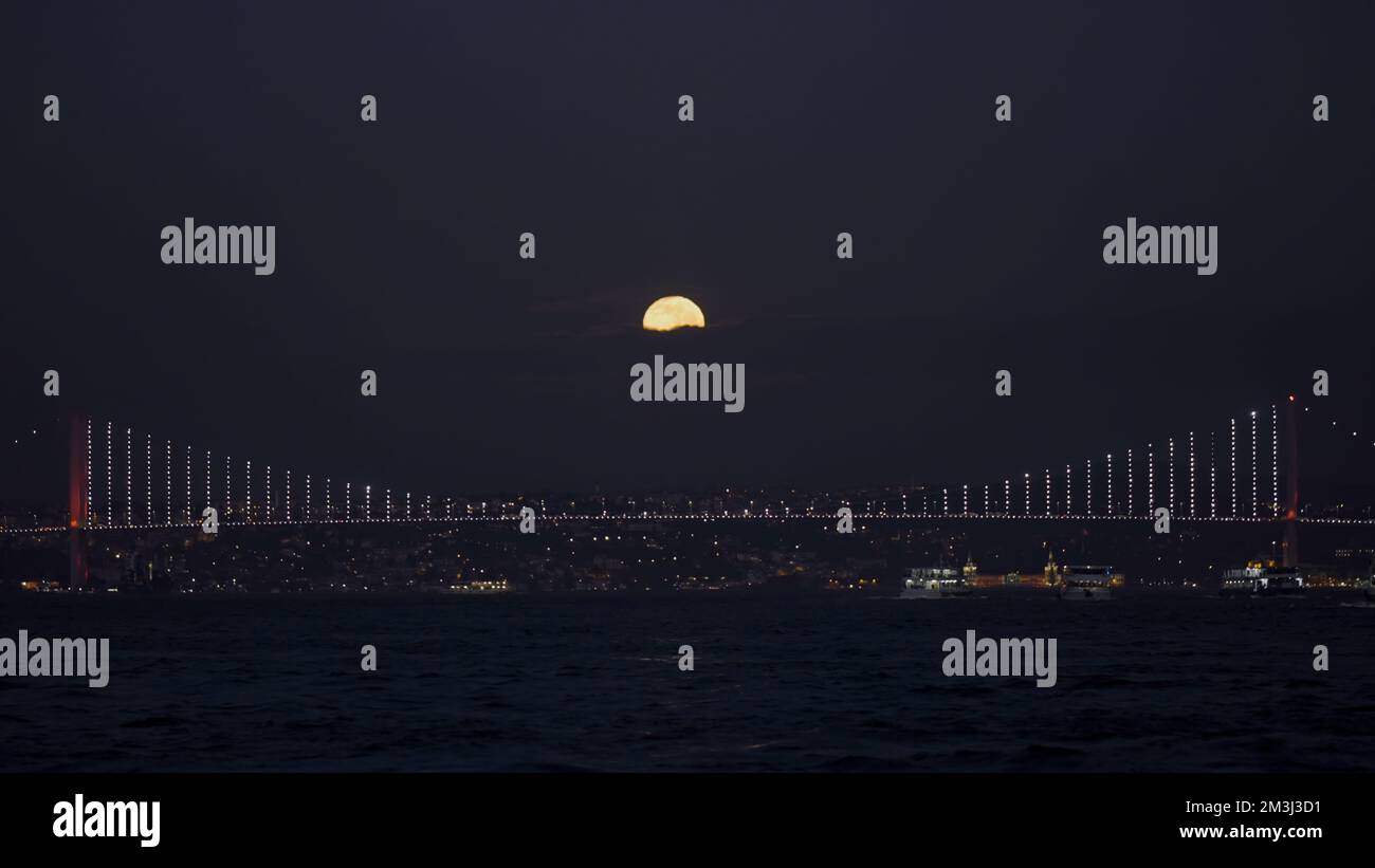 Night breathtaking landscape with a river, bridge, and a dark sky with ...