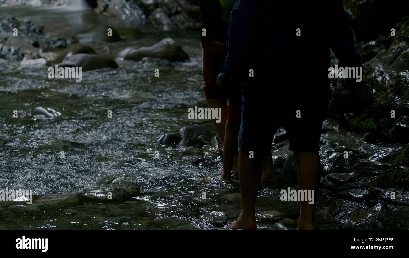 People walking barefeet in rocky mountainous river. Creative Summer ...