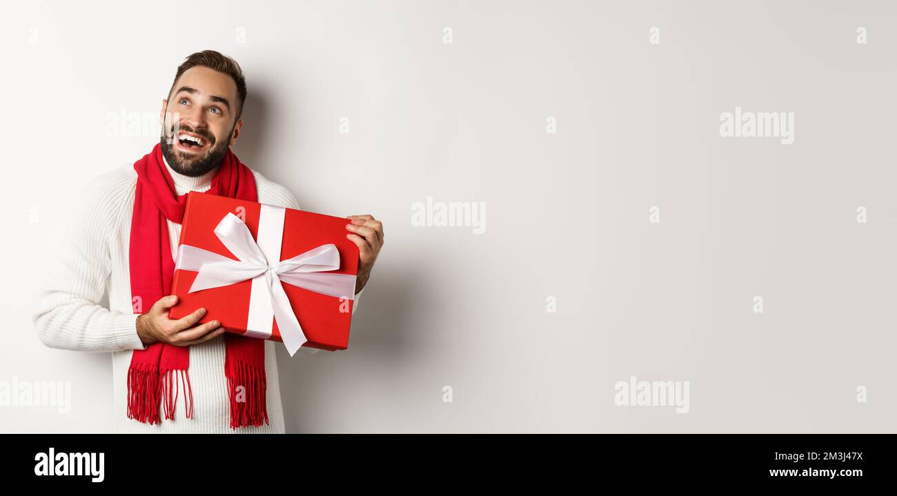 Merry Christmas. Happy man looking ecstatic and holding his New Year ...