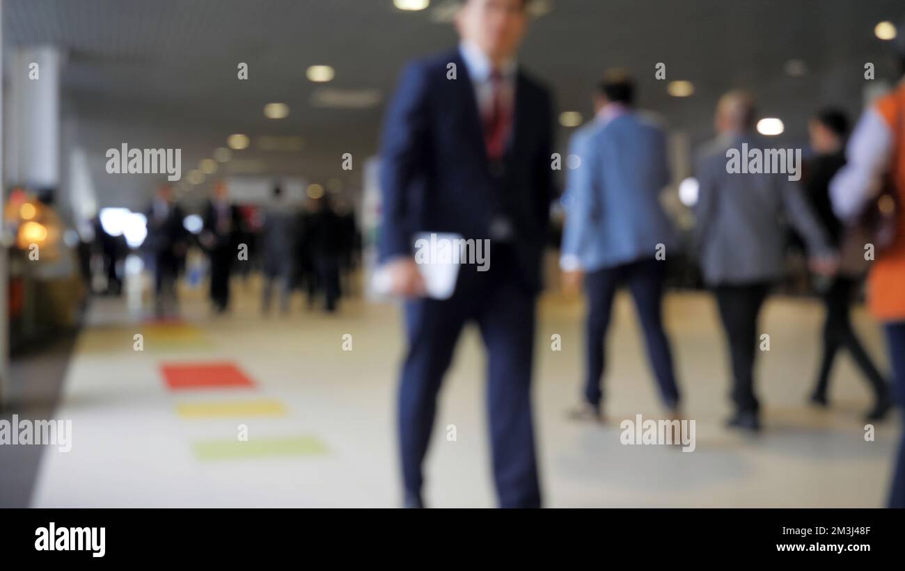 Blurry view of businessmen walking in lobby. Media. A lot of ...