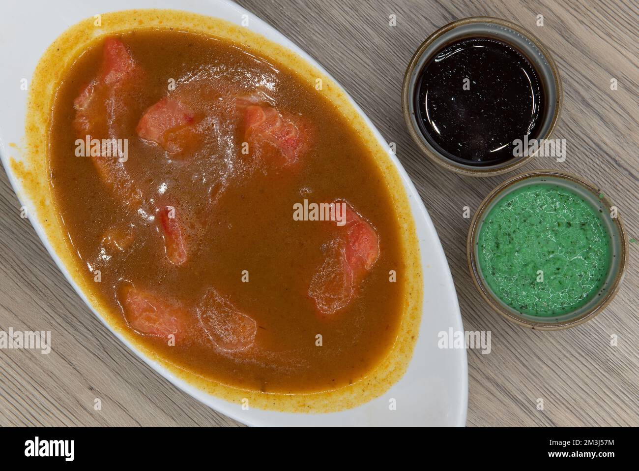 Overhead view of spicy bowl of traditional Indial meal, fish curry ...