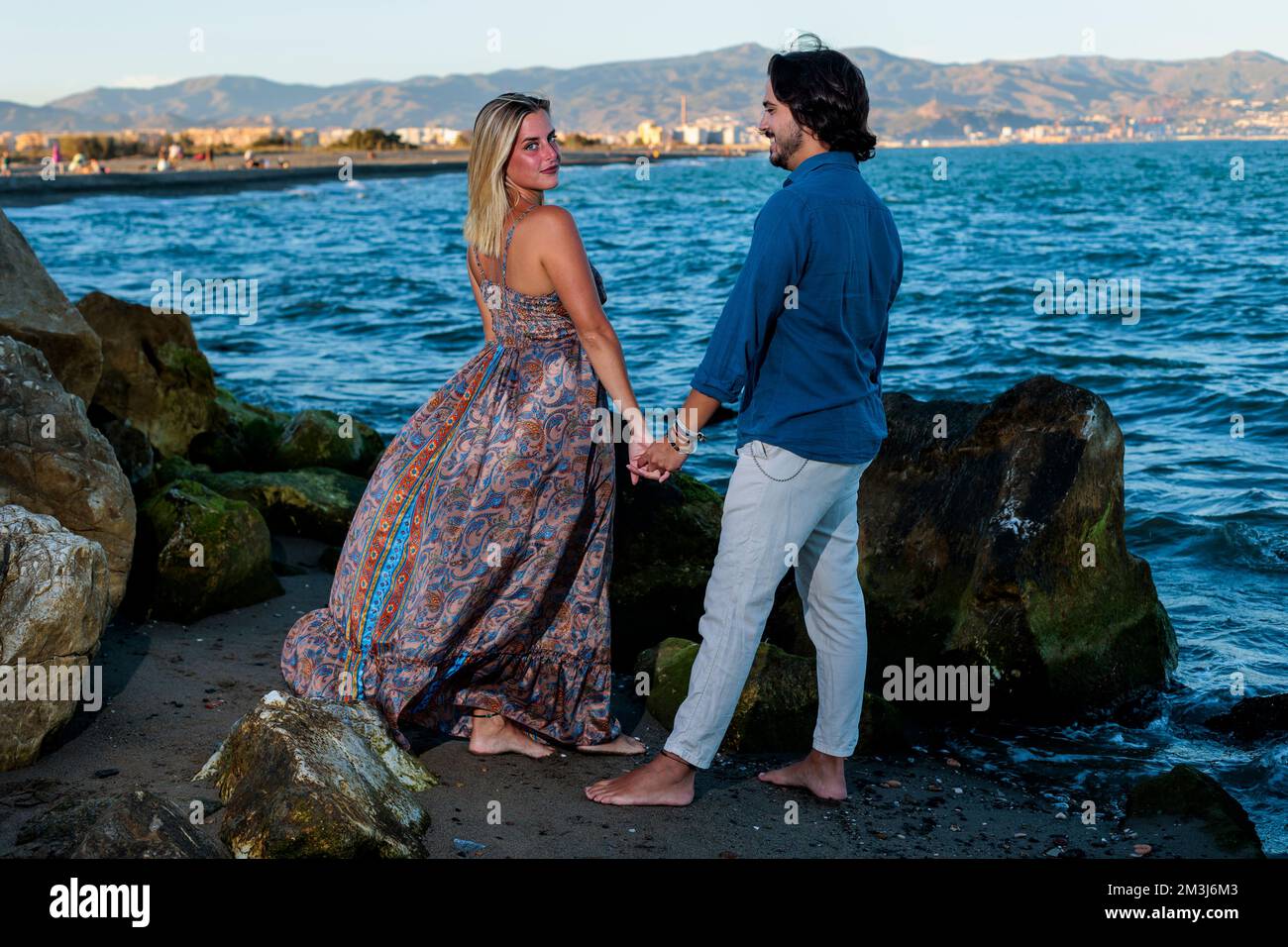A cute couple holding hands lovingly standing on the beach Stock Photo ...