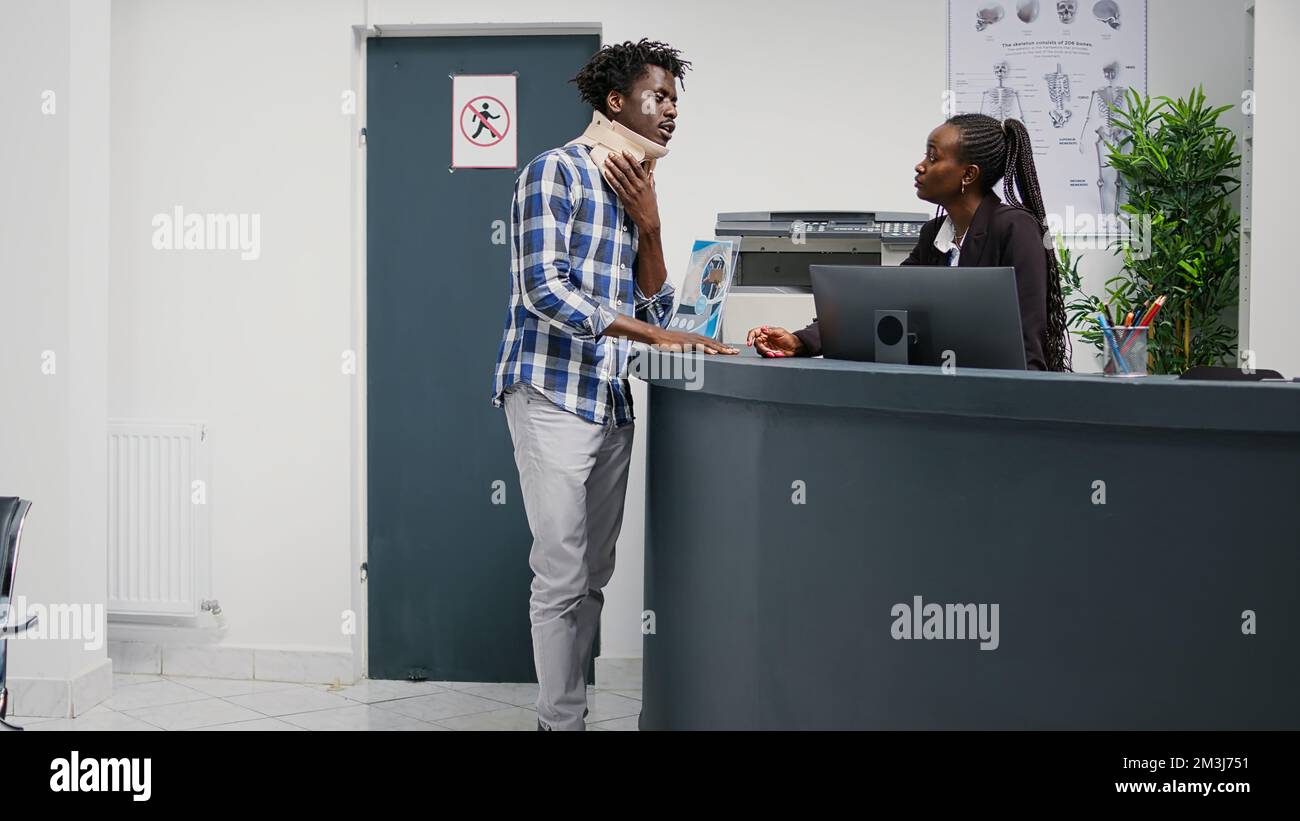 African american man wearing cervical neck collar in waiting room lobby ...