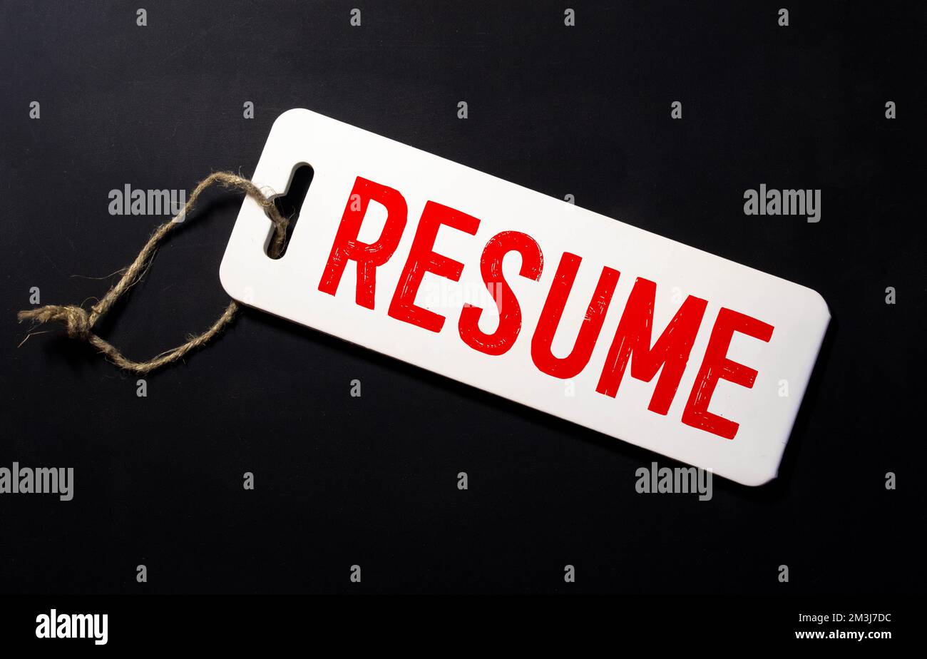 businessman holding a card with text RESUME Stock Photo - Alamy