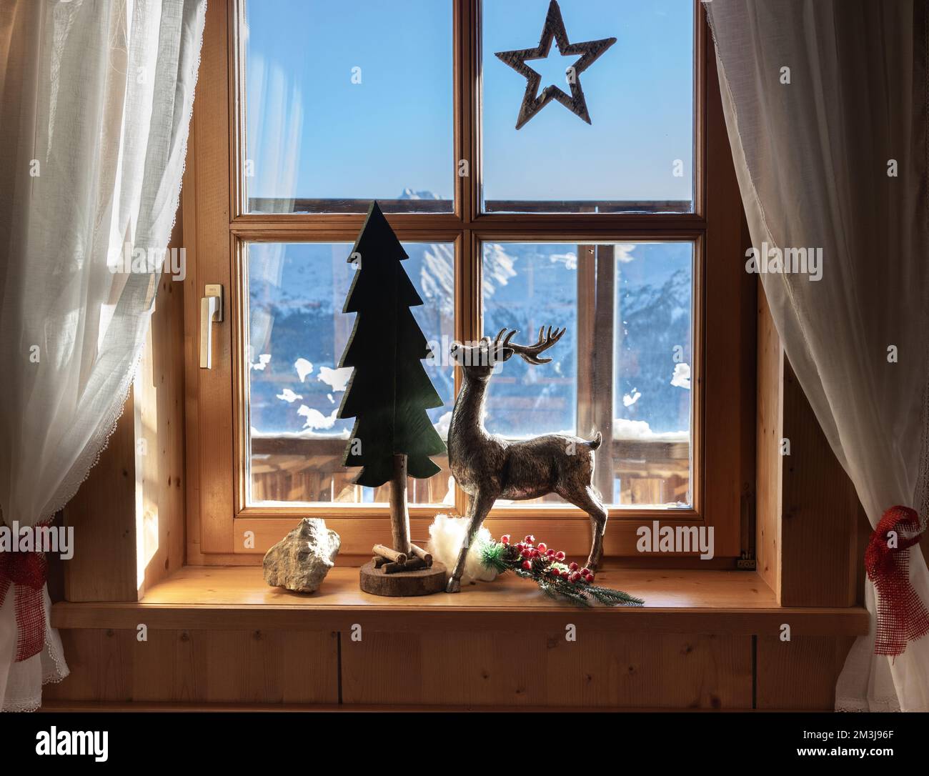 Window in a mountain hut overlooking a mountain range, decorated for ...