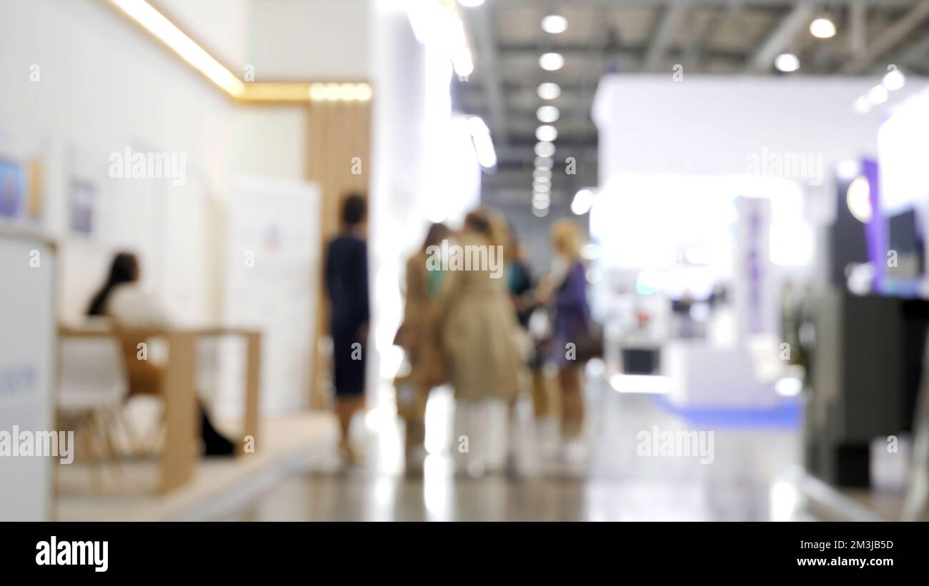 Blurred crowd of people passing by in a shopping or business center ...