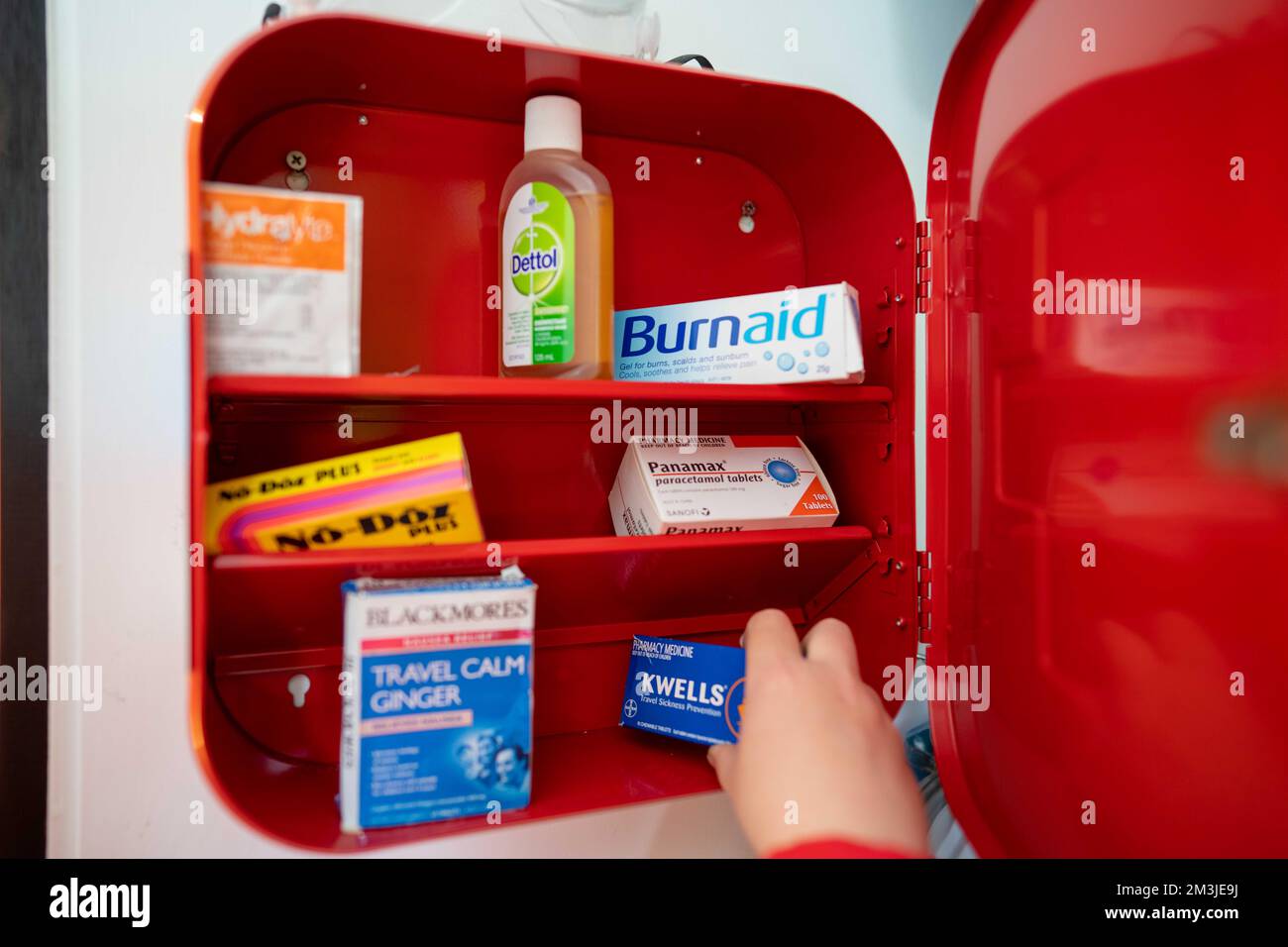 red first aid kit mounted to the wall full of supplies. red first aid ...