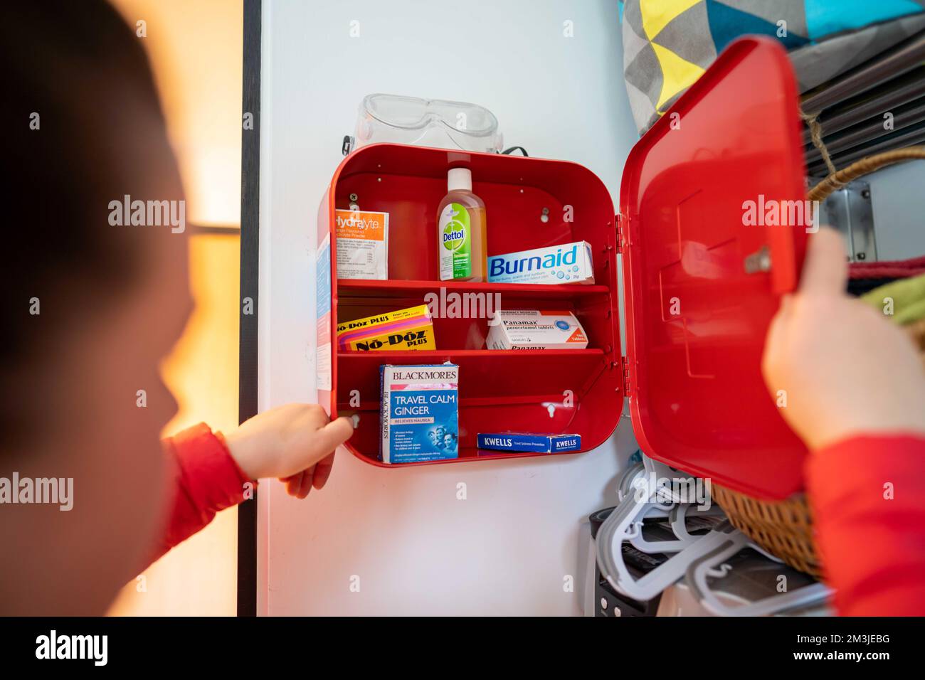 red first aid kit mounted to the wall full of supplies. red first aid ...