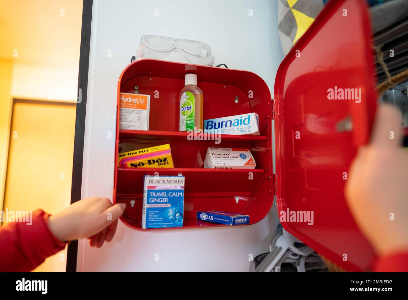 red first aid kit mounted to the wall full of supplies. red first aid ...
