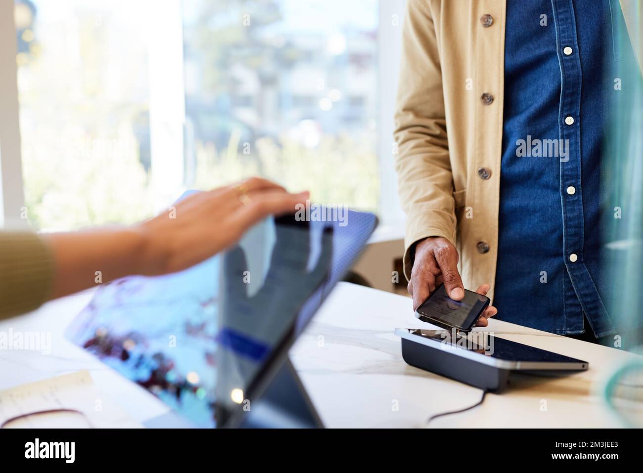 Male customer taping smart phone on POS system in coffee shop Stock ...