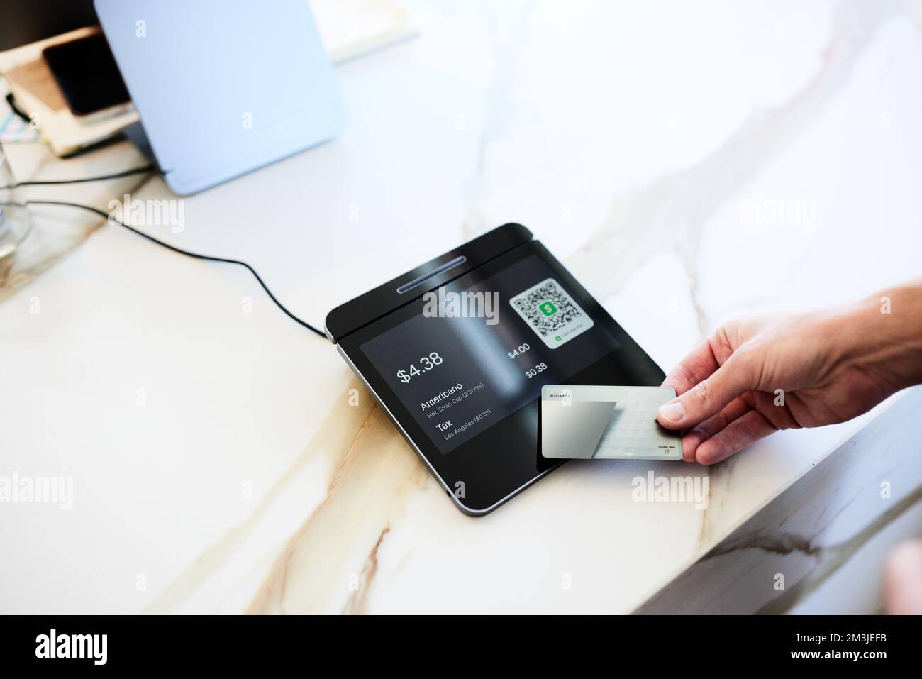 Hand of male customer paying with credit card on modern POS system ...