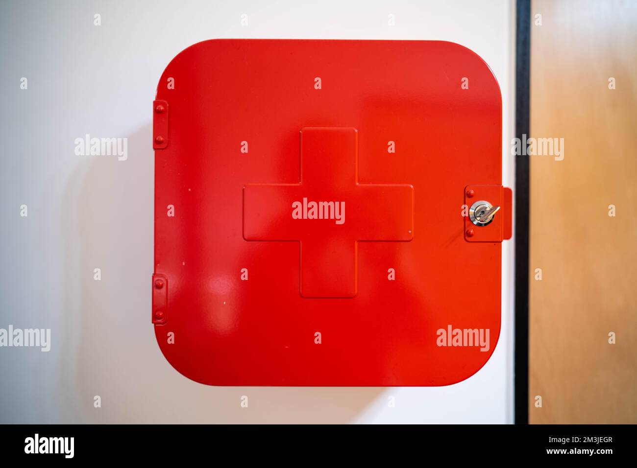 red first aid kit mounted to the wall full of supplies. red first aid ...