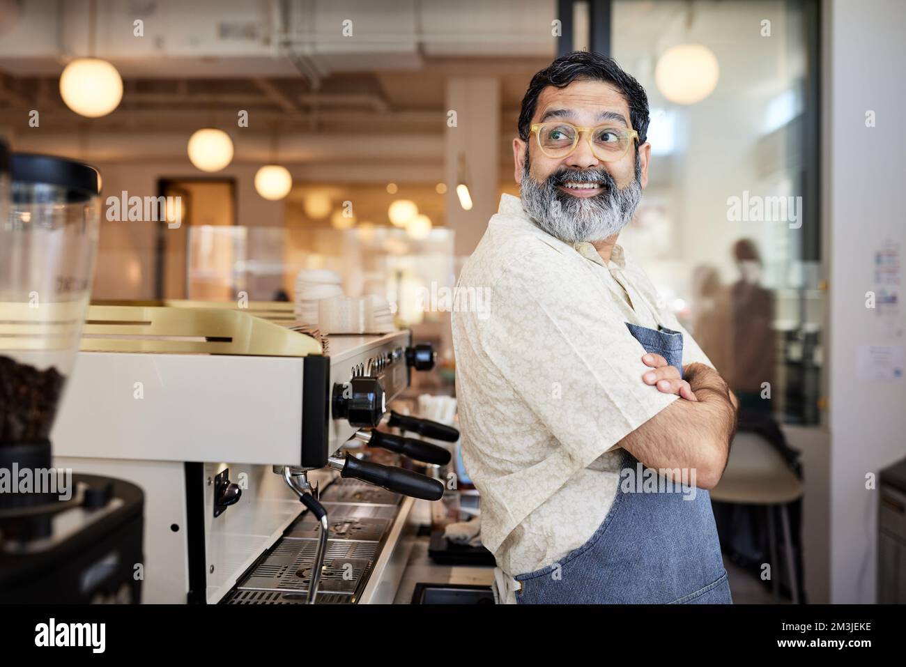 Smiling male barista wearing eyeglasses leaning on coffee machine Stock ...