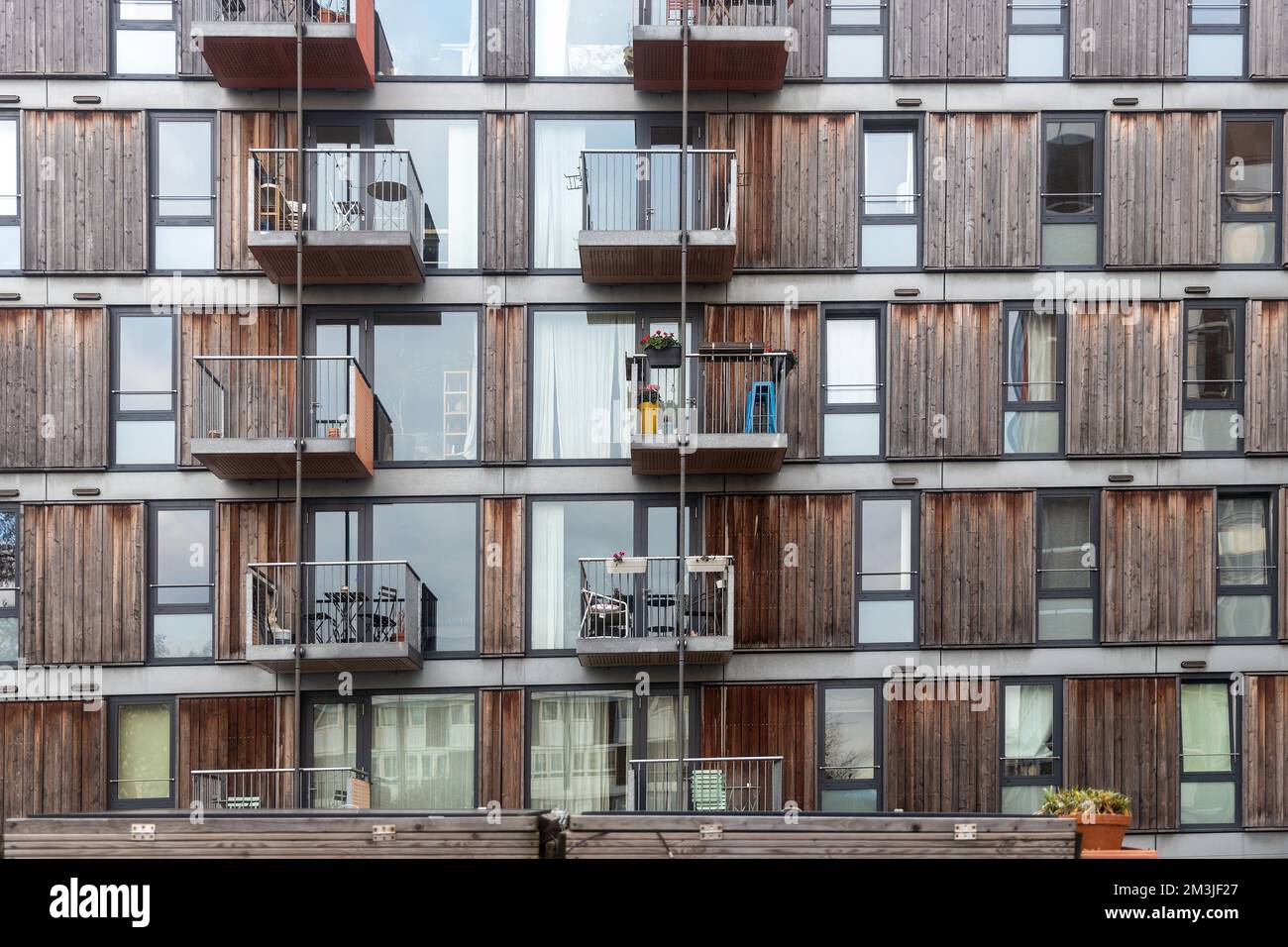 fragment of a facade of a building with balcony with table and chair ...