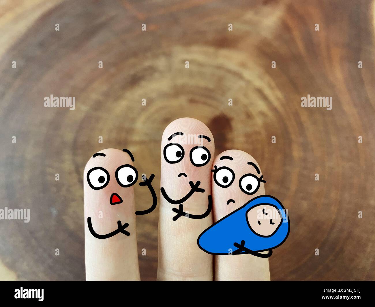 Three fingers are decorated as three person. One of them is holding a ...