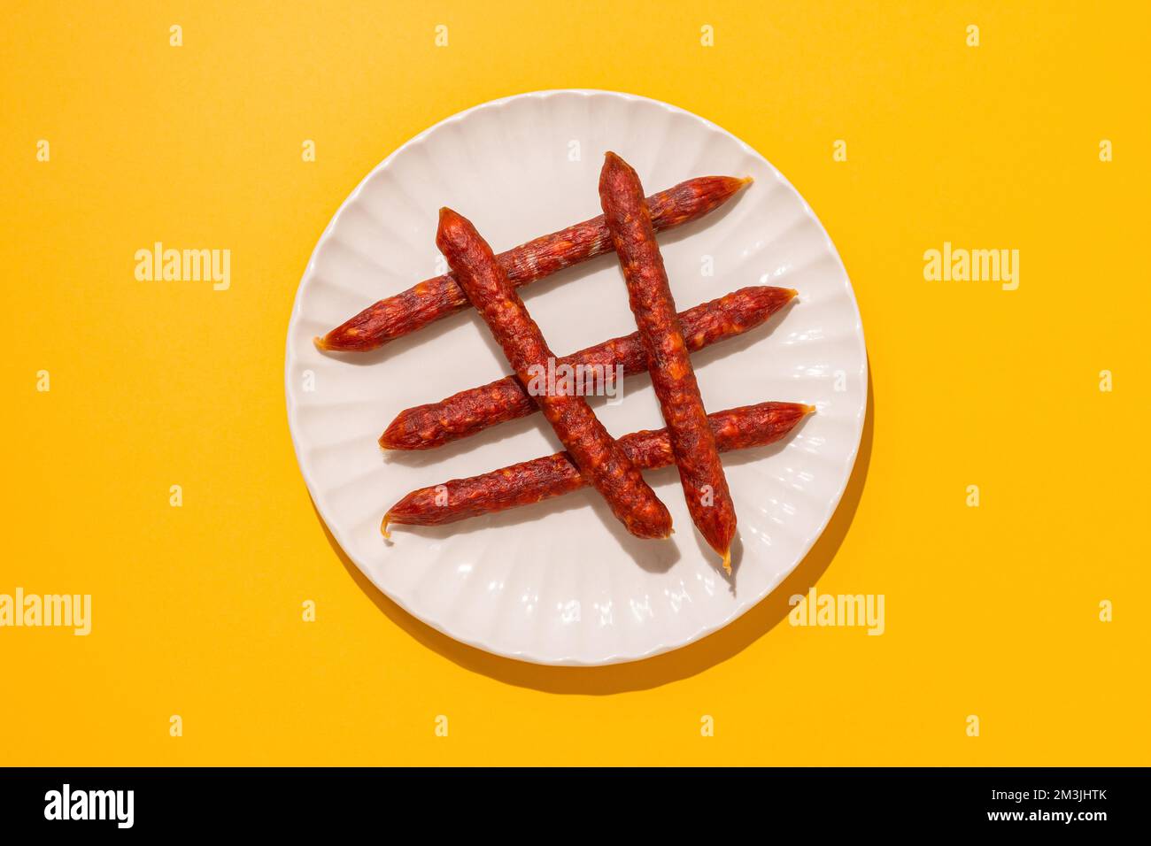 Flat lay of Spanish mini chorizo on yellow Stock Photo - Alamy