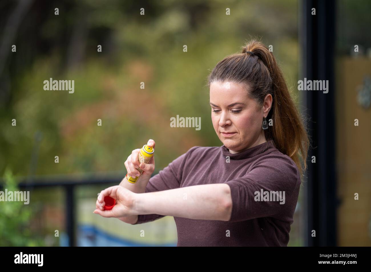 woman applying bug spray, girl spraying on bug spray in australia Stock ...