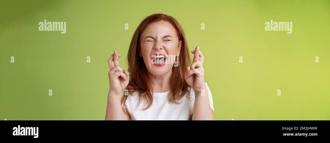 Woman implore god protection. Close eyes yelling thrilled cross fingers ...