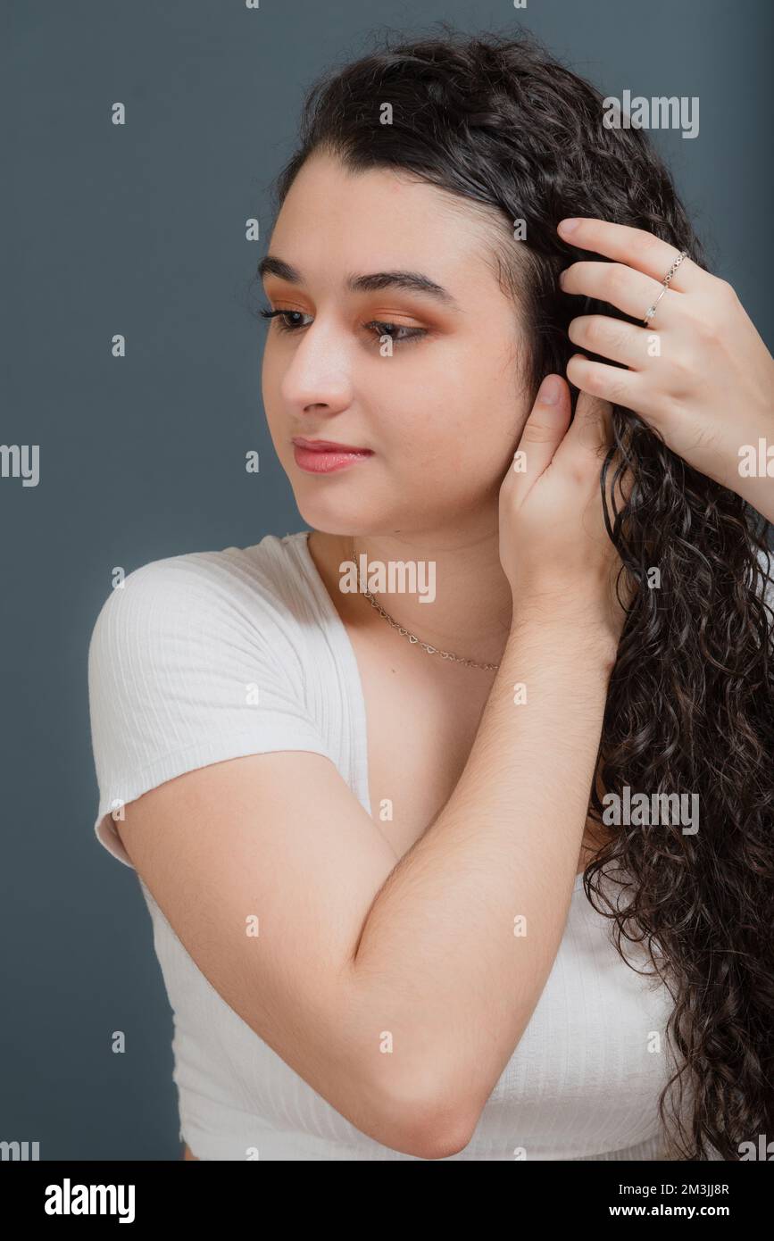 Young beautiful girl smiling happily messing with her hair. Youth ...