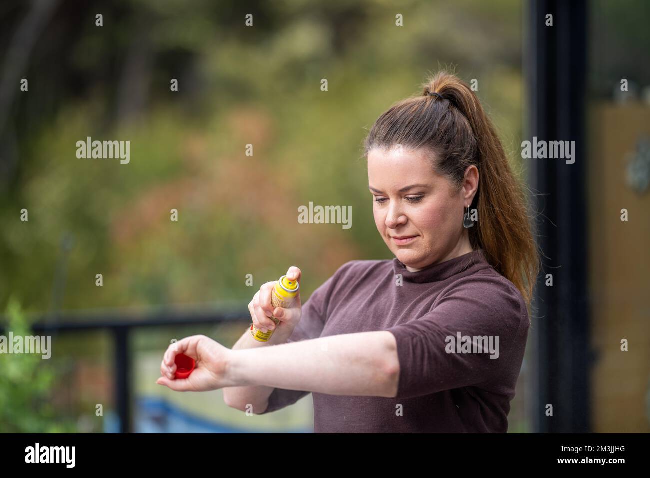 woman applying bug spray, girl spraying on bug spray in australia Stock ...