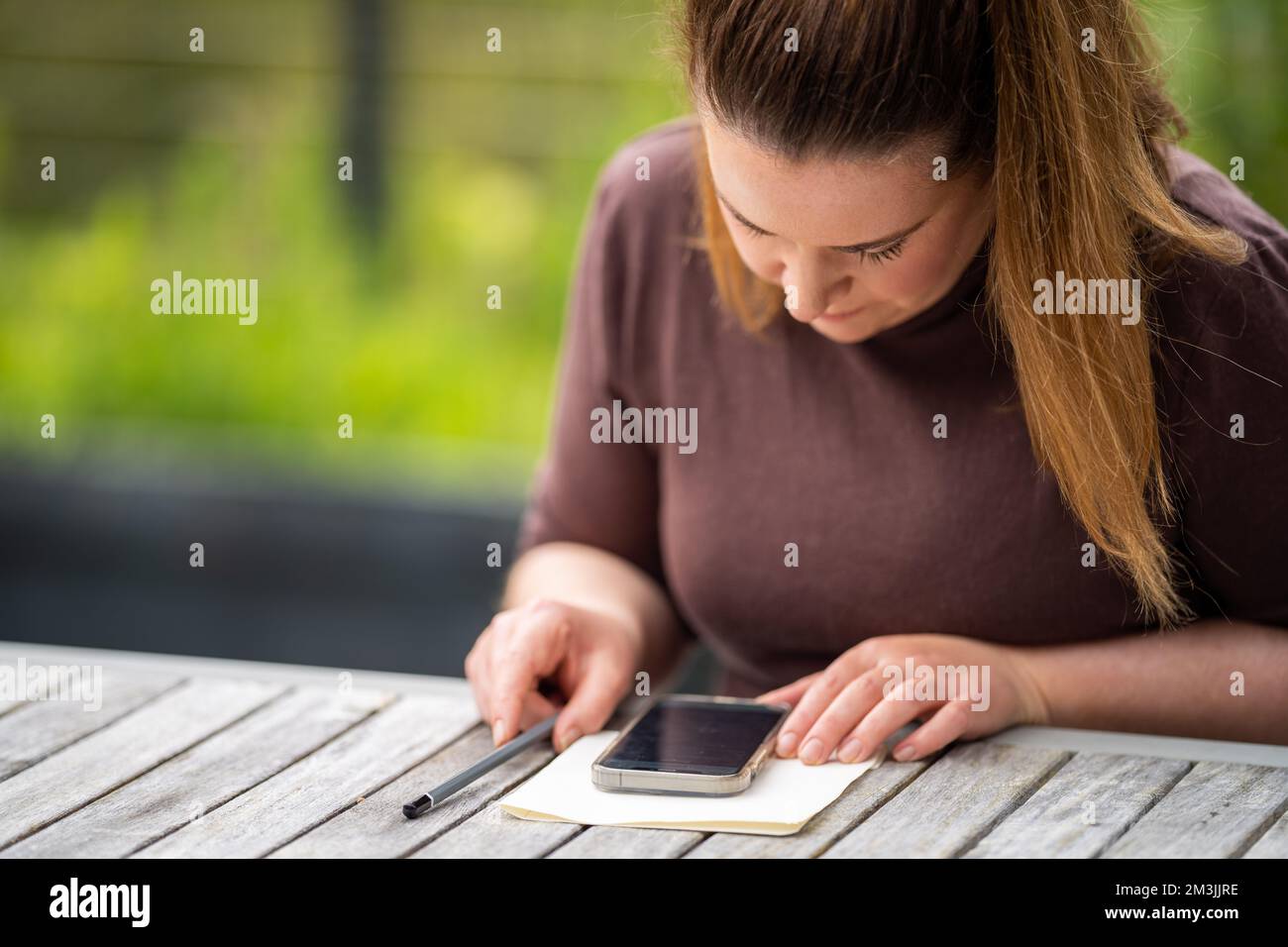 girl working on her phone, working remote in the country in australia ...