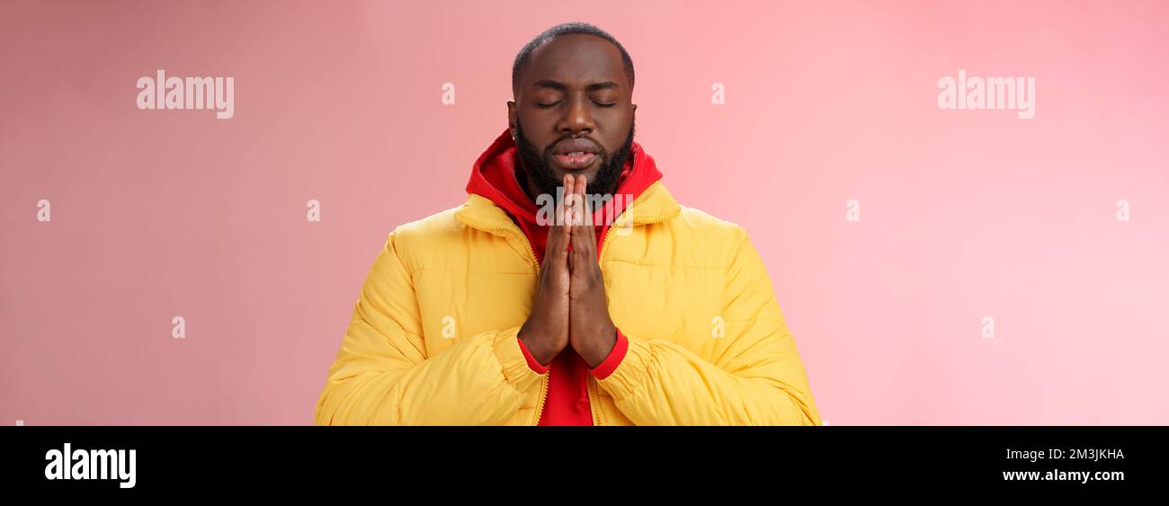 Serious-looking faithful young determined african-american praying guy ...