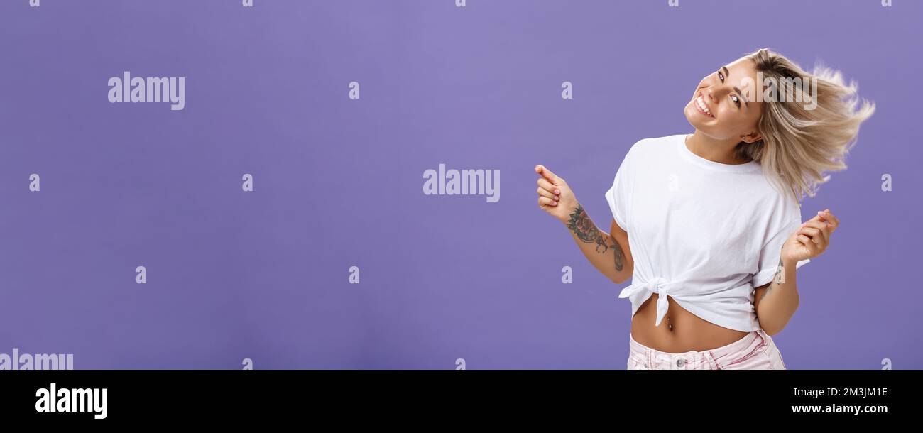 Portrait of happy carefree attractive woman dancing and waving hair ...