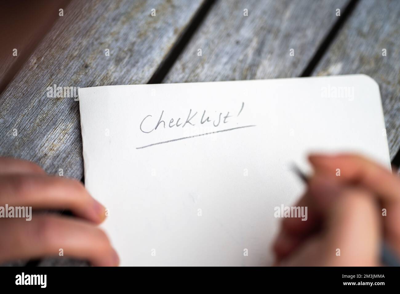 gril writing a camping list in a piece of paper. writing a check list ...