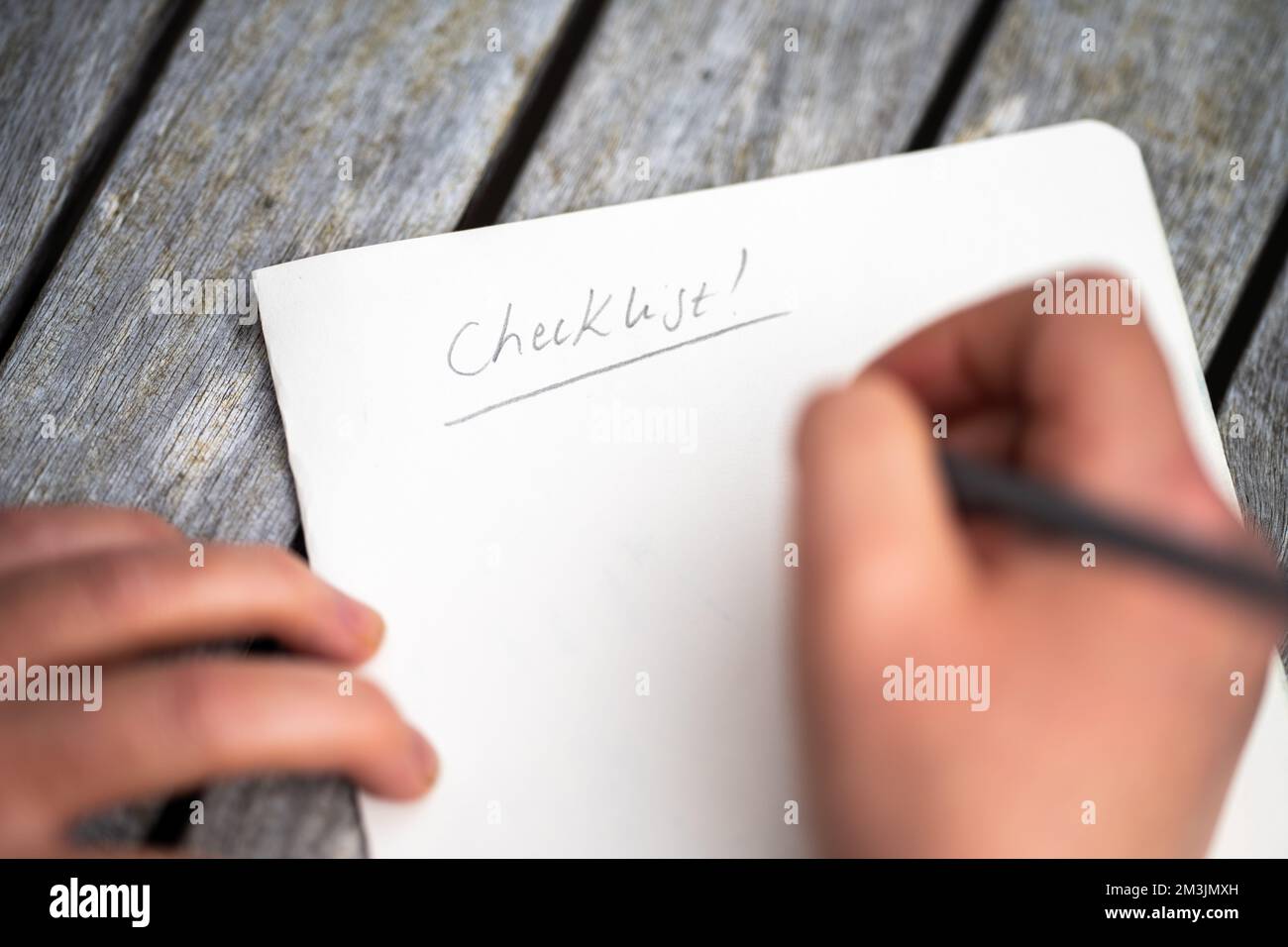 gril writing a camping list in a piece of paper. writing a check list ...