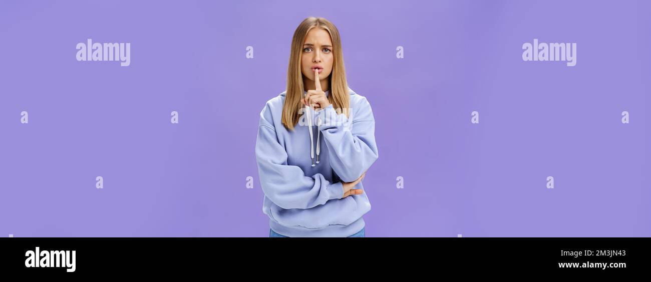 Girl concerned someone know secret making shush gesture with index ...