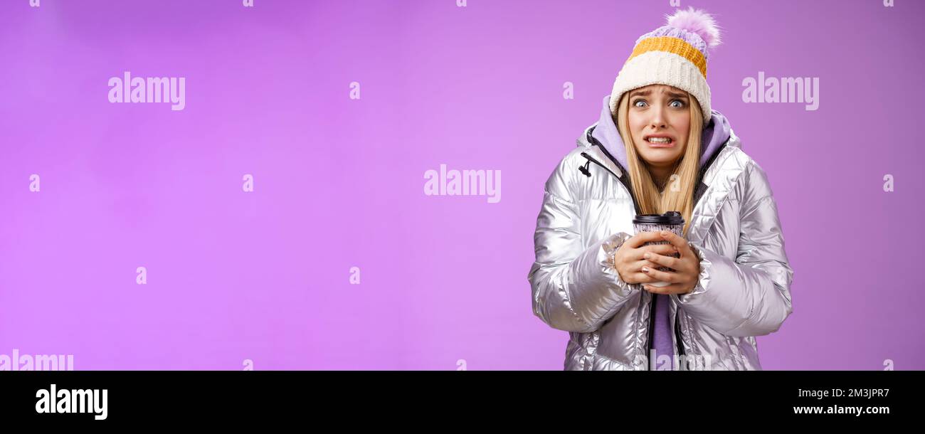 Shaking uncomfortable displeased girl wearing stylish silver jacket hat ...