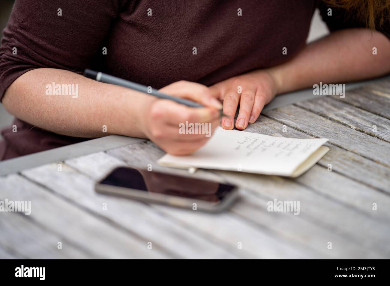 gril writing a camping list in a piece of paper. writing a check list ...