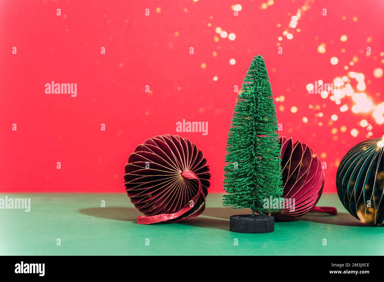 Christmas paper baubles and fir tree on red and green background with ...