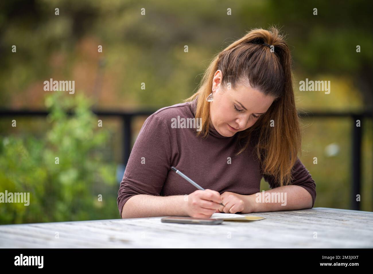 mature university student writing outside studying in australia Stock ...