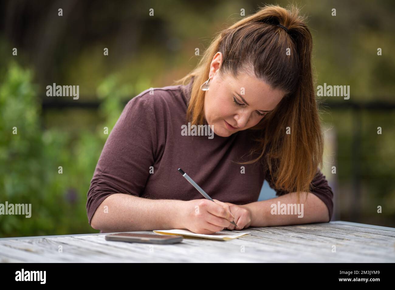 mature university student writing outside studying in australia Stock ...