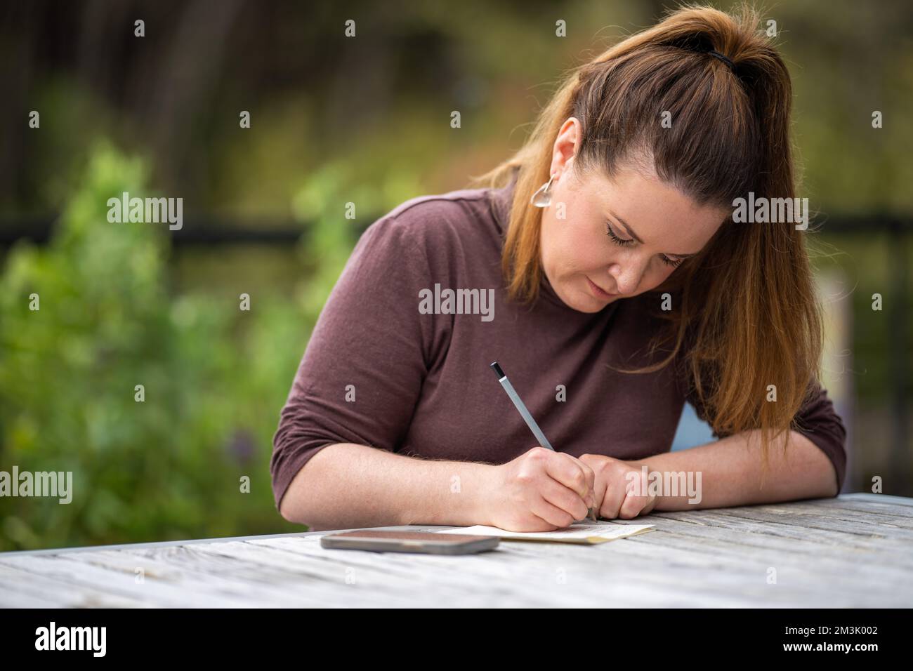 mature university student writing outside studying in australia Stock ...