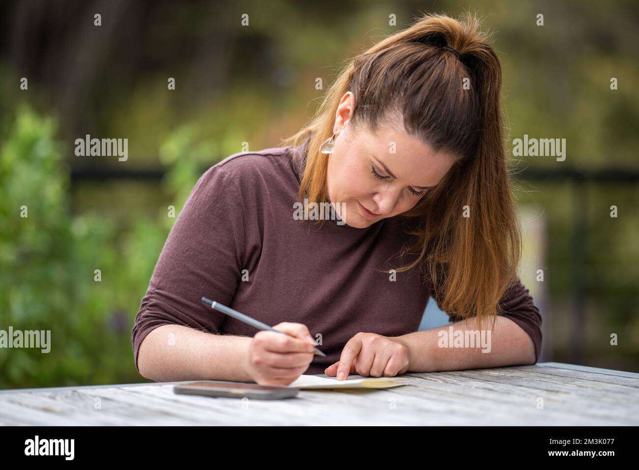 mature university student writing outside studying in australia Stock ...