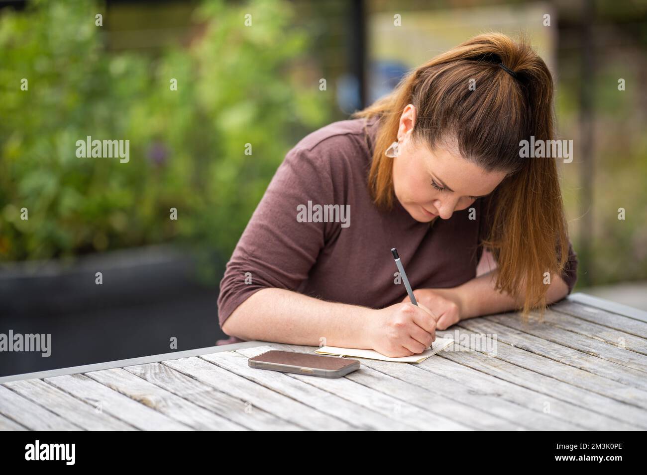 mature university student writing outside studying in australia Stock ...