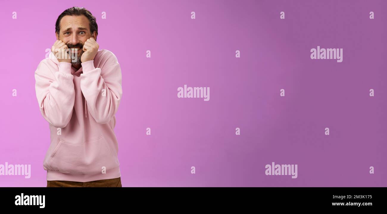 Scared insecure silly adult bearded man grey hair in pink hoodie press ...
