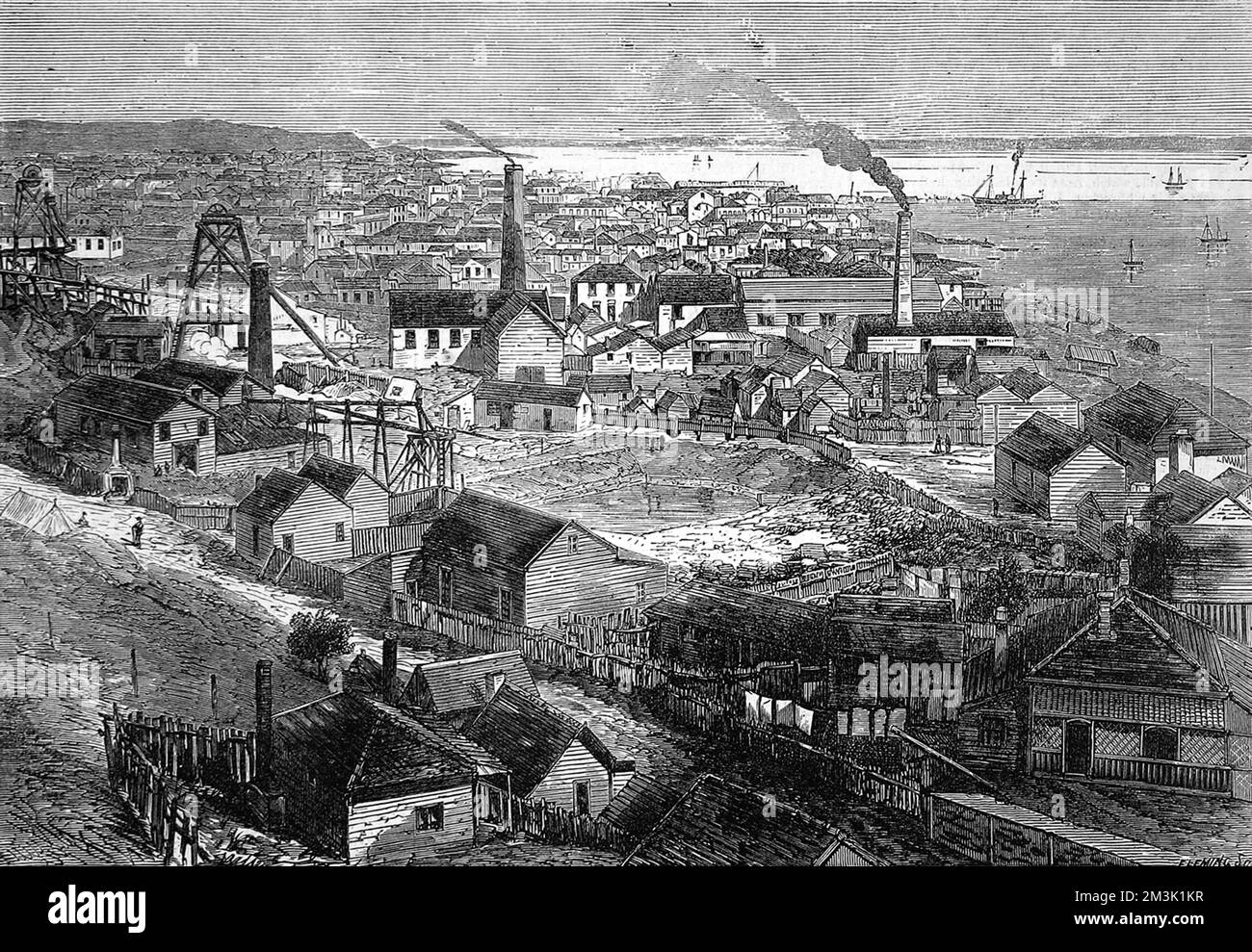 Small town with wooden framed houses, towers and industrial chimneys ...