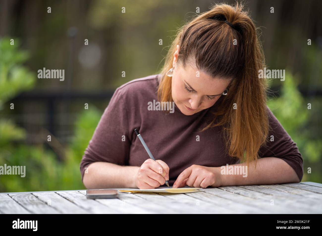 mature university student writing outside studying in australia Stock ...