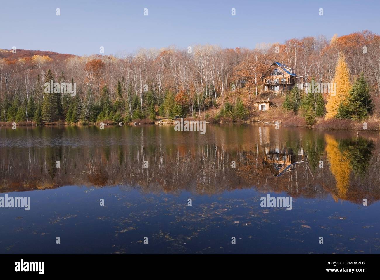 A-frame style log cabin on edge of calm lake in autumn Stock Photo - Alamy